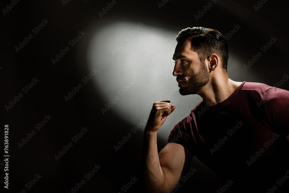 Portrait in profile of serious strong bearded modern man over dark ...