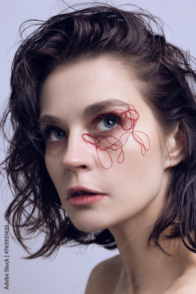 Portrait of beautiful young woman with deep blue eyes, red tangled ...