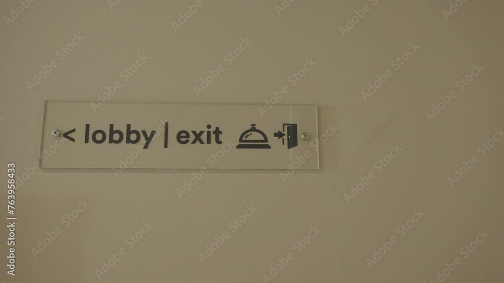 Navigation sign on beige wall of hotel corridor with direction of lobby ...