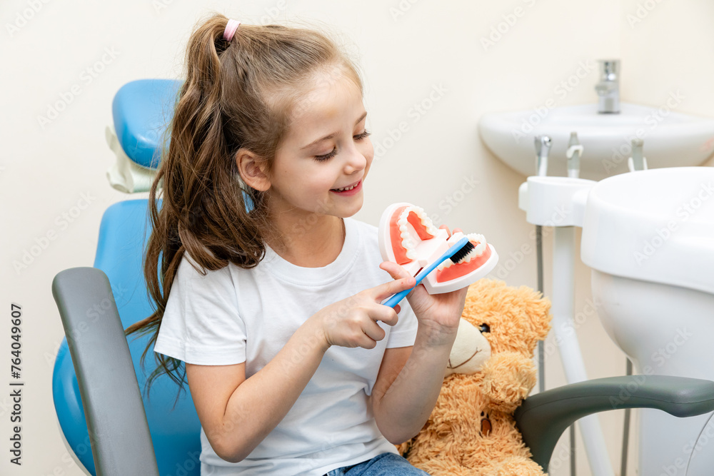 Girl is practicing how to properly brush her teeth. Good oral hygienist ...