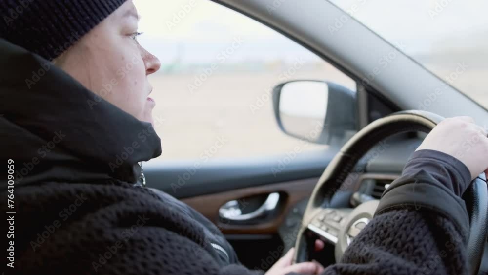 Overweight adult woman in profile driving a car in a desert area in ...