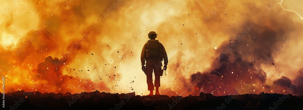 A man standing in front of a raging fire, flames reaching high into the ...