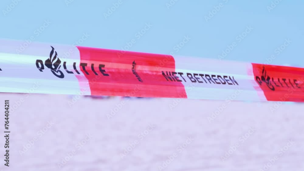 Crime scene on sandy beach marked with red and white police tape ...