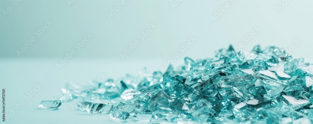 pile of crushed recycled glass on the right against a pale blue ...