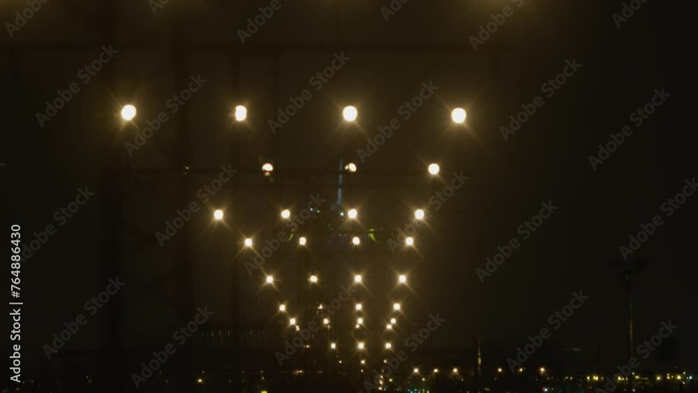 An aircraft glowing navigation lights captured mid-descent, framed by ...