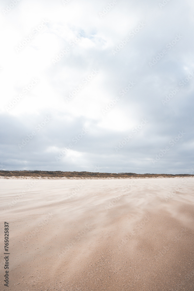 Sand grains break off the ground and form currents due to high winds on ...