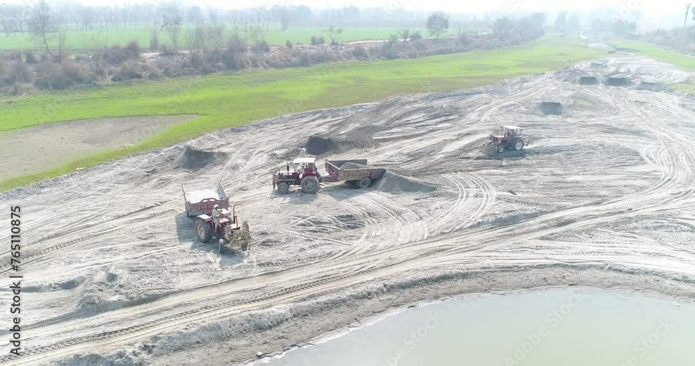 Vidéo Stock Ariel View of the tractor is filling soil in the trolley ...
