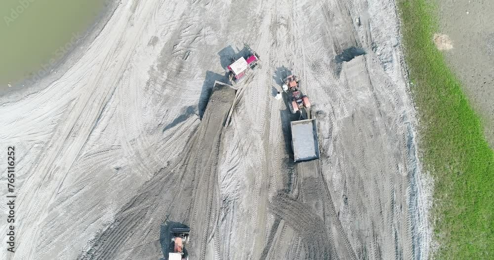 Ariel View of the tractor is filling soil in the trolley with tractor's ...