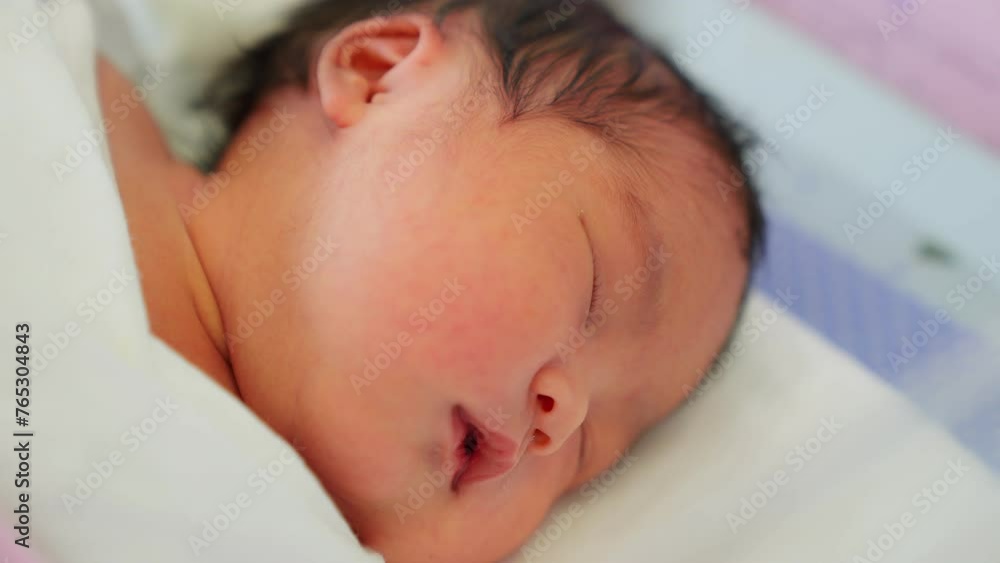 Asian face of happy newborn baby lying sleeps on a blanket comfortable and safety in the ...