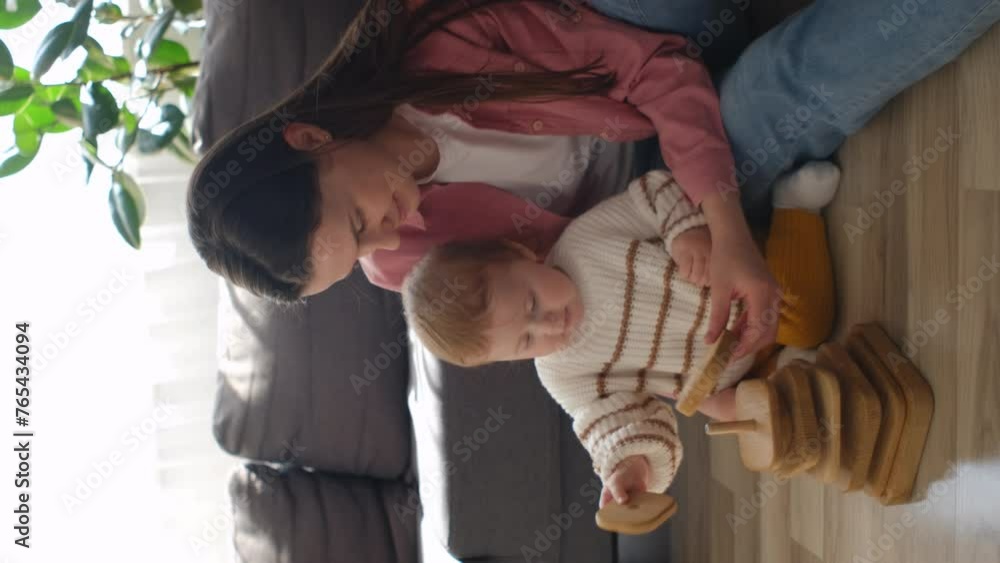 Vertical video of happy nanny spend time in modern cozy home with ...