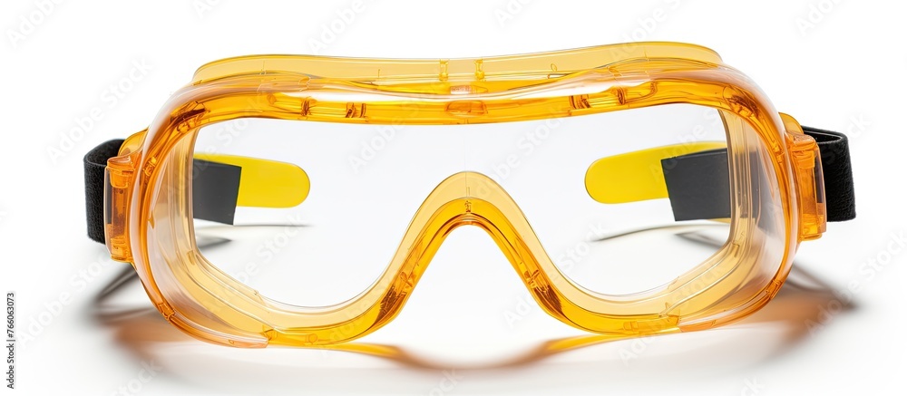 Yellow safety goggles, a eye glass accessory, rest on a white ...