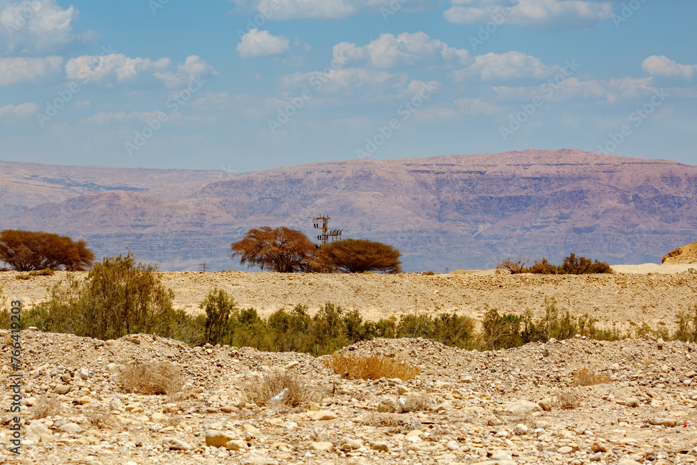 Sparse greenery dots a dry Negev desert foreground. A barren landscape ...