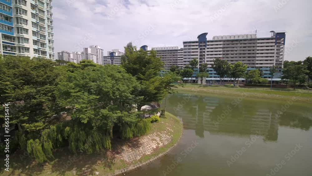 Drone of Kallang River with trees and small bridge along the modern ...
