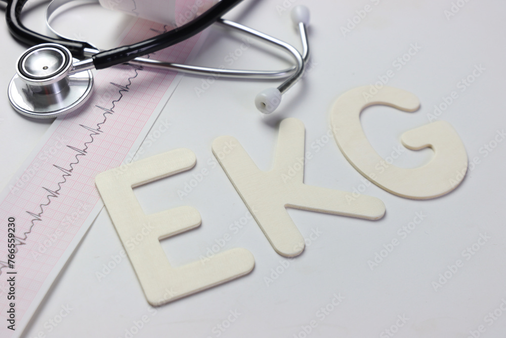 Ekg letters in a white background with a ekg paper and a stethoscope ...