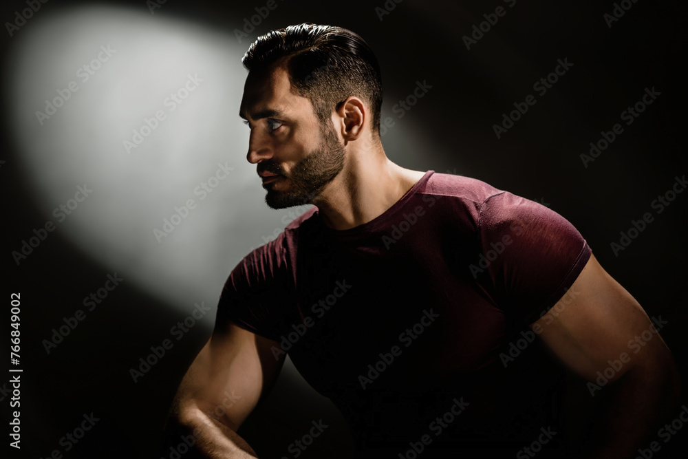Portrait in profile of serious strong bearded modern man over dark ...