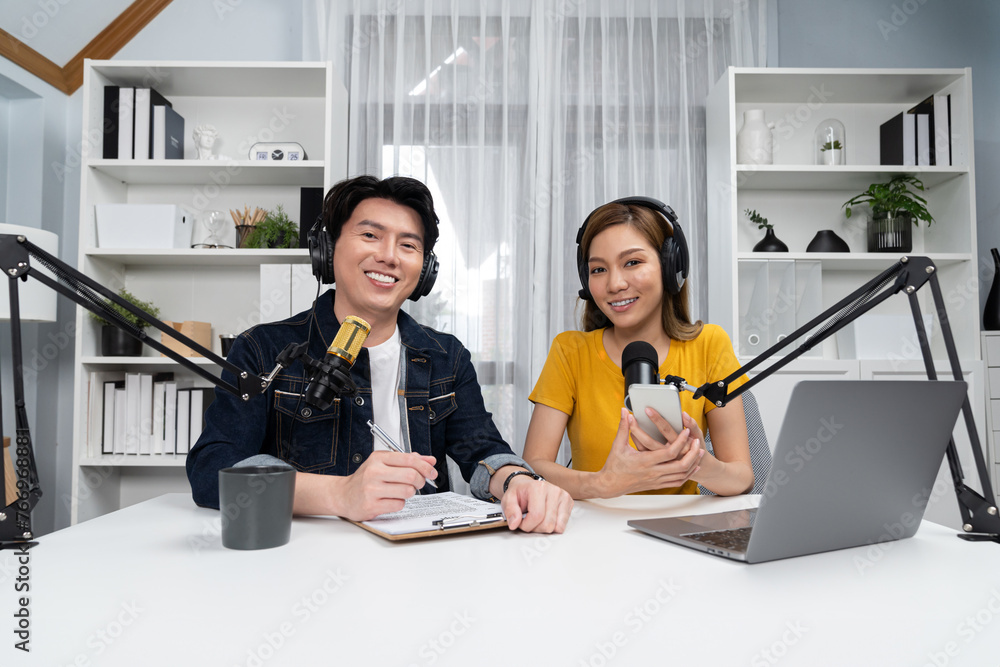 Smiling radio influencer hosts wearing headphones looking camera to ...