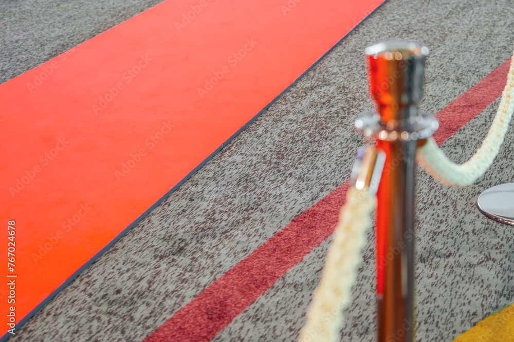 Red carpet in focus, rope fencing with gold pillars with for ...