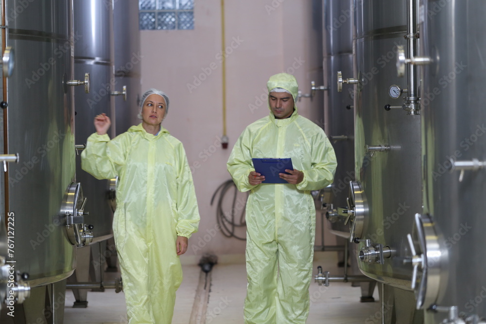 Winemaker woman and business owner wearing a sterile suit working and ...