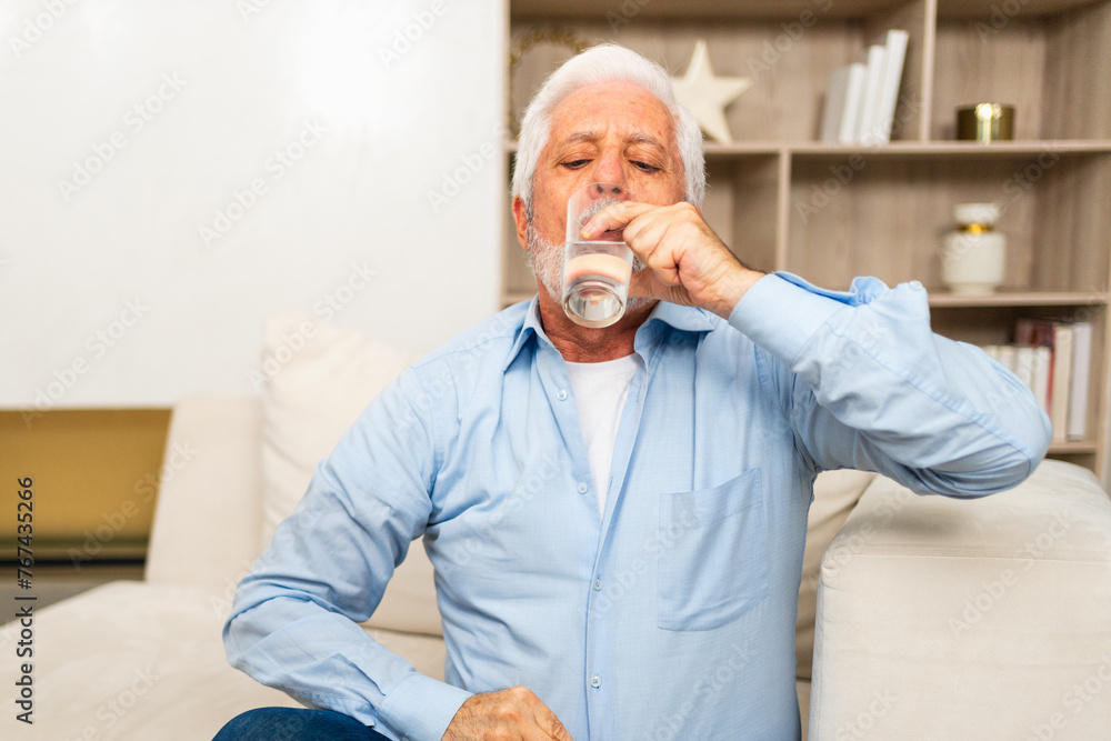 Senior man holding glass drinking fresh water at home. Mature old ...