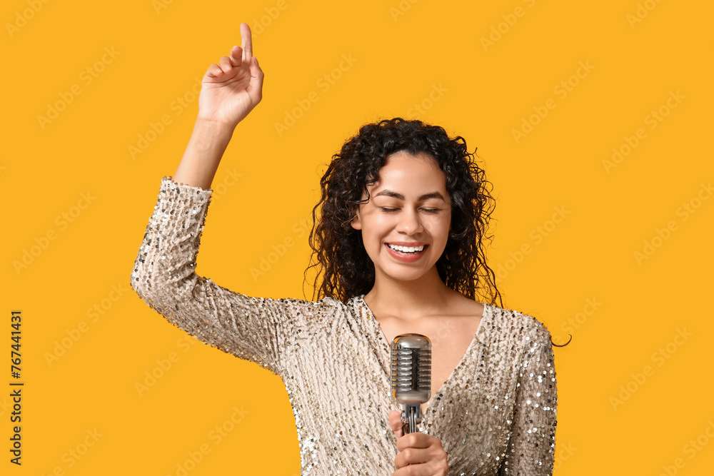 Beautiful young happy African-American female singer with microphone ...