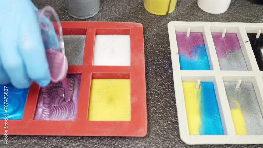 Carpentry joiner pouring pink colour epoxy resin from plastic cup into ...