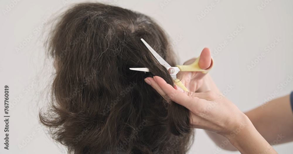 Cut off lock of hair. Woman's hand cuts off lock of hair on man's head ...