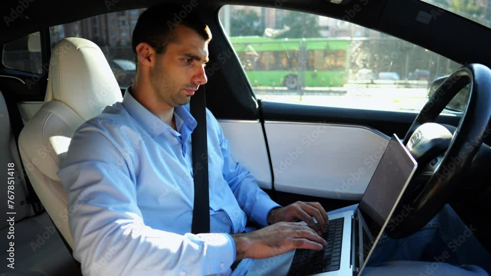 Handsome entrepreneur working on notebook while riding an autonomous ...