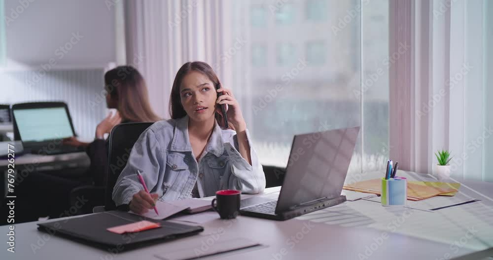 Asian India teen staff girl sitting desk chair use laptop hold mobile ...