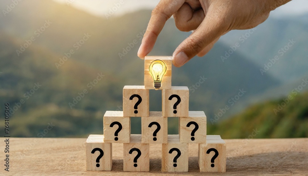 Hand put the last wooden cubes on the top of a pyramid built by wood ...