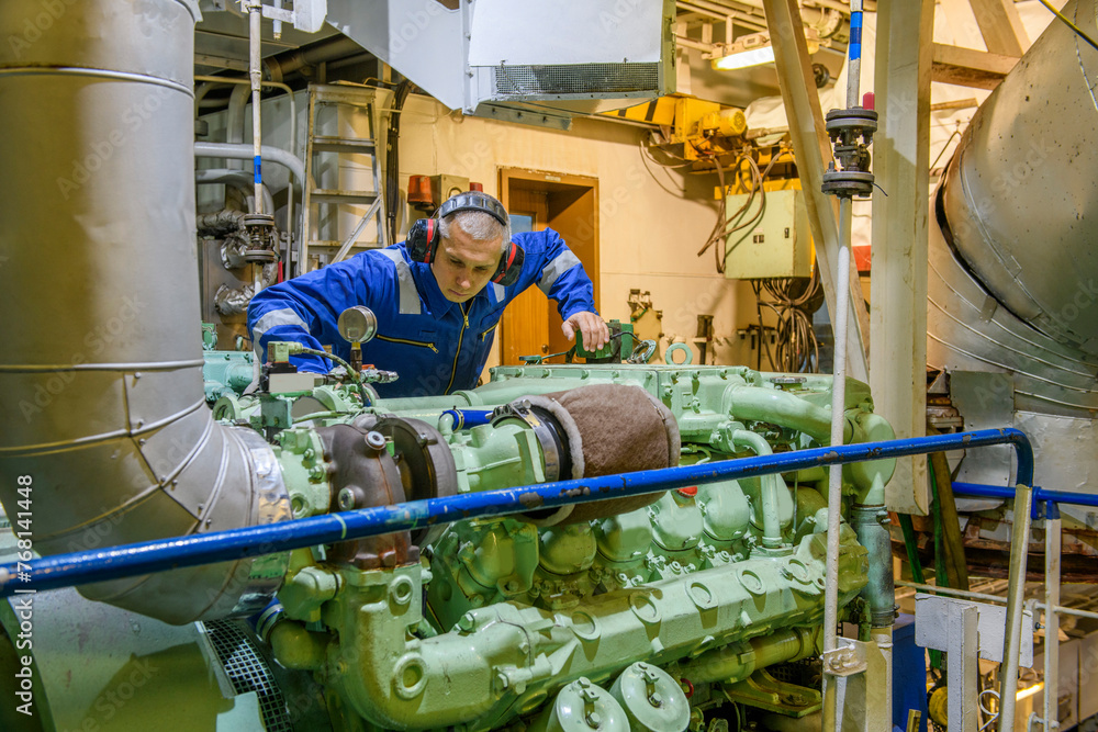 Marine Engineer in blue overall working in Engine room of ship. Work at ...