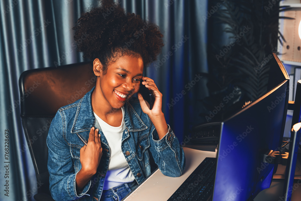Young African creator calling with smartphone and looking on screen ...