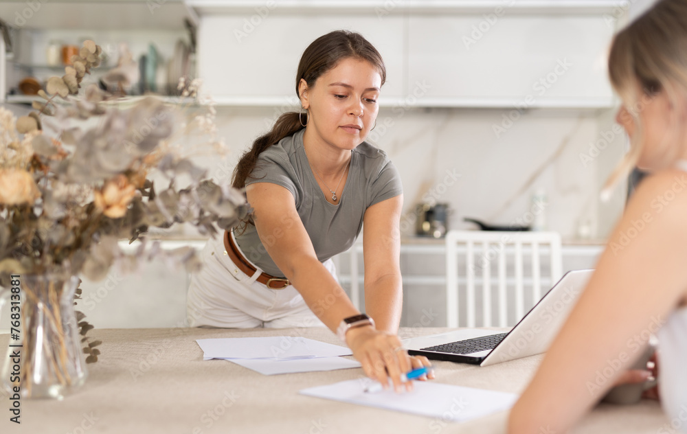 Girl agent communicates with client while sitting at table in kitchen ...