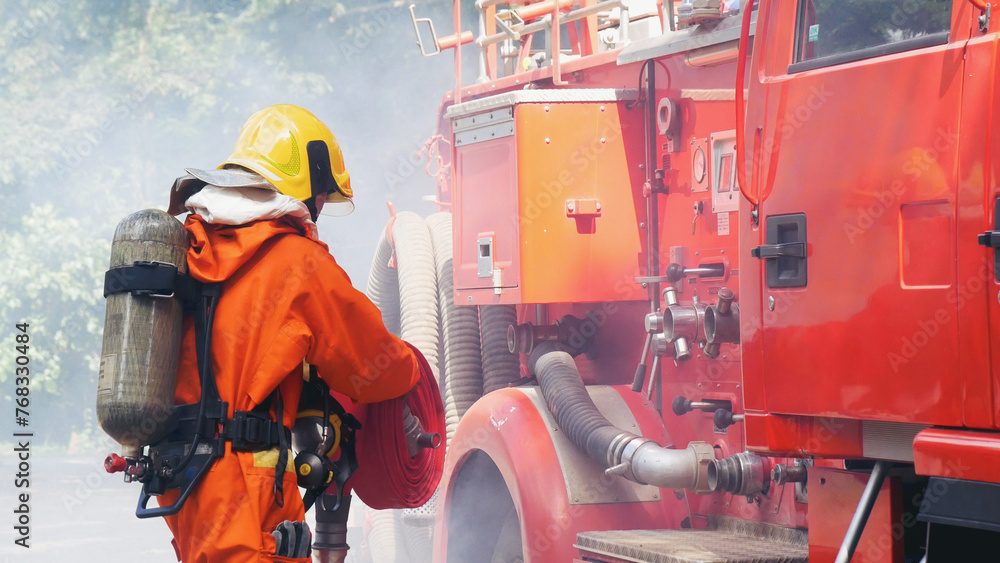 Fireman prepare equipment at fire engine truck. Man hand connect water ...