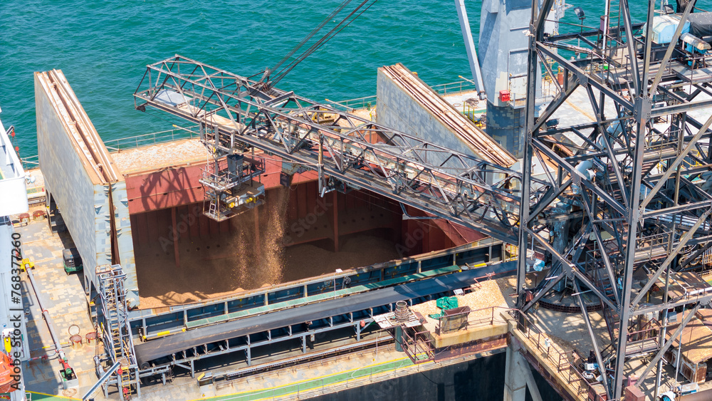 Aerial top view wood chips load chip from silo to cargo ship vessel ...