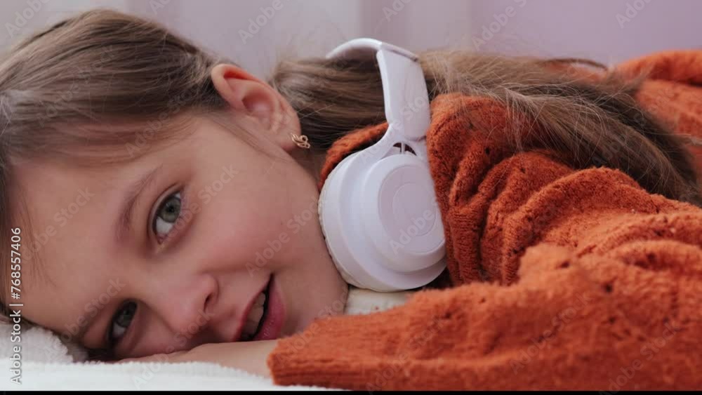 Calm adorable little brown haired girl sleeping with wireless headphone ...