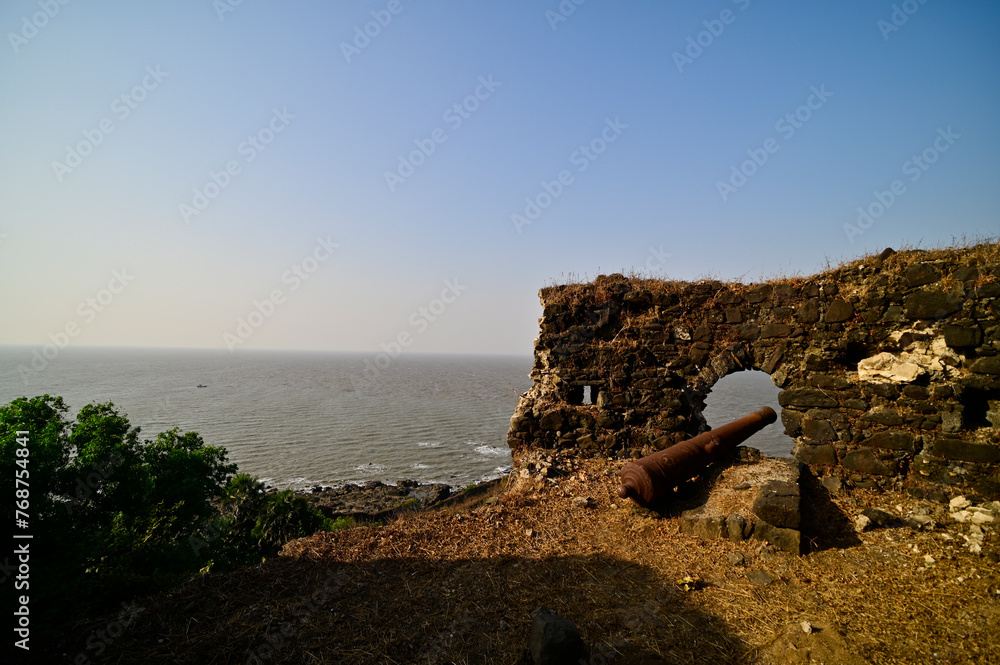 Old war cannon lying among the ruins of Korlai fort. A naval defense ...