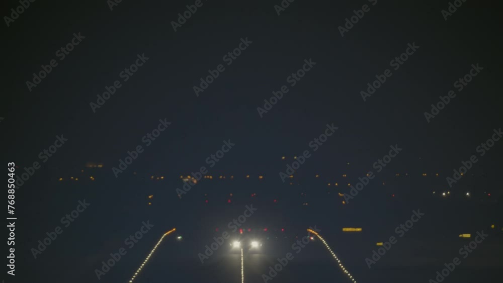 An airplane activates its front and wing lights during a night takeoff ...