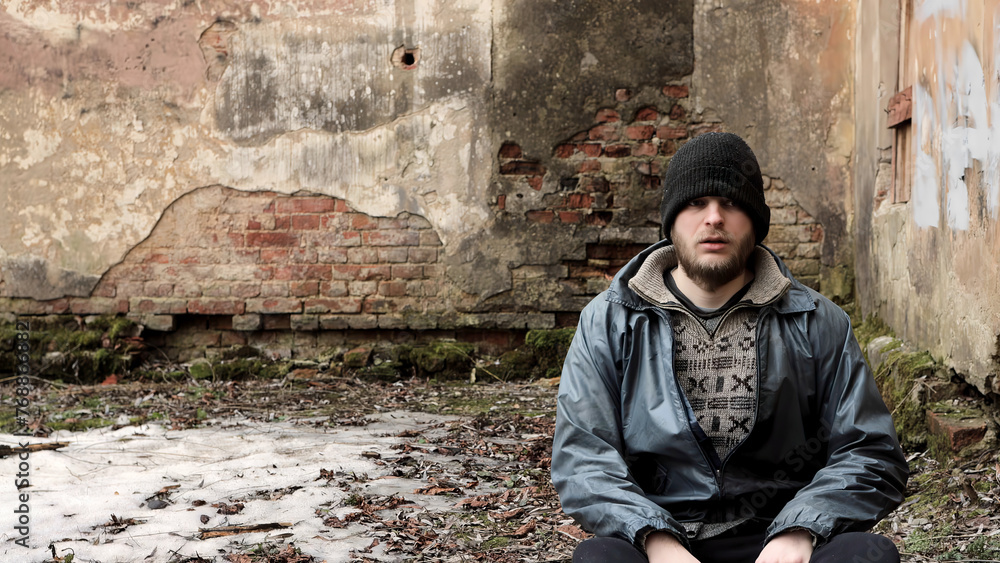 Civilian sitting inside war-ravaged building. Homeless man sits at ...