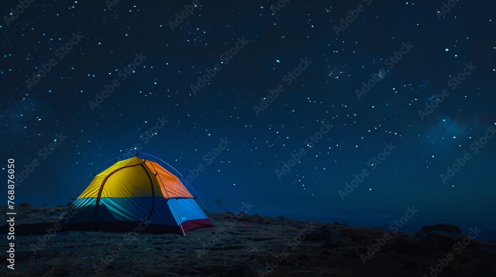 A photo of a brightly colored tent pitched beneath a star-filled summer ...