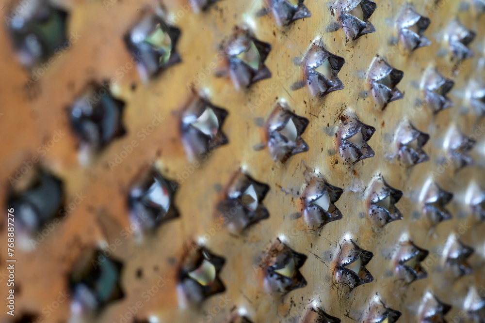 This image presents a detailed close-up view of a metal grater ...