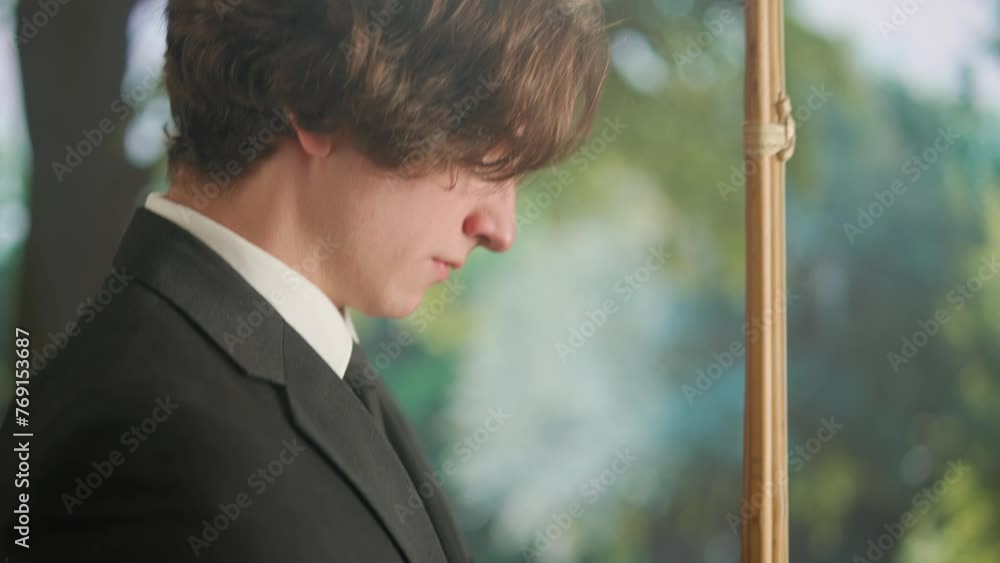 Person with sword posing at camera. Young man in suit with japanese ...
