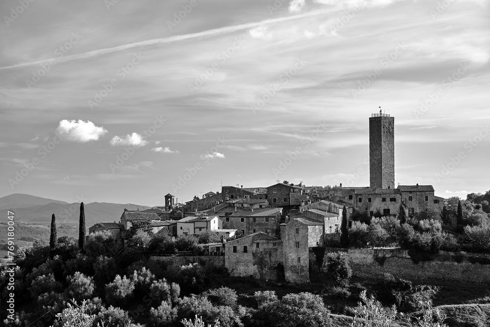 stone houses, bell tower and medieval tower on top of a hill in the ...