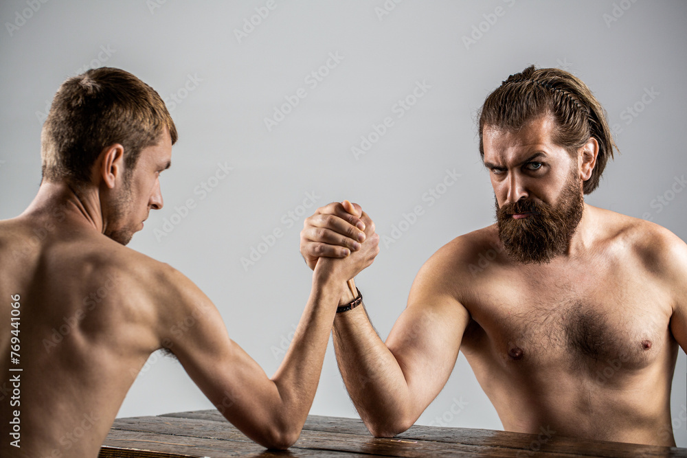 Arms wrestling thin hand, big strong arm in studio. Two man's hands ...