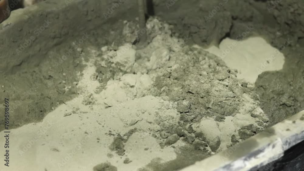 Cement plaster, mortar. Stirring cement mortar with a hammer drill ...