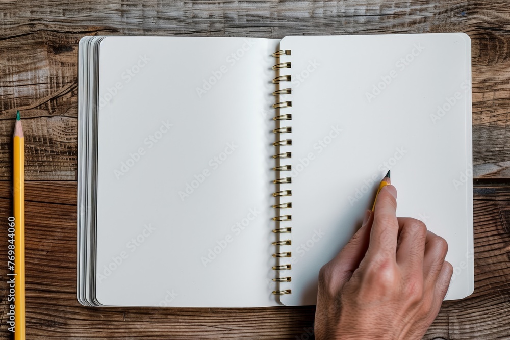 hand flipping blank page in a notebook, pencil tucked in the spiral ...