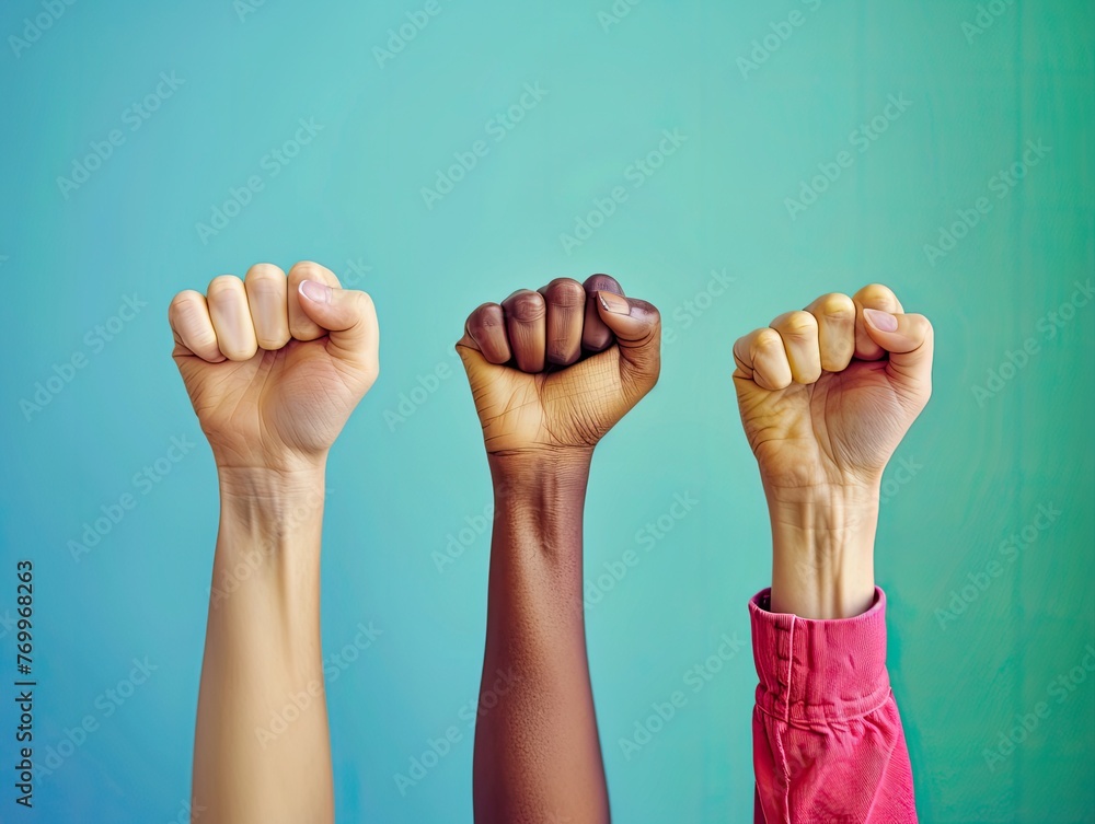 Diverse group of people raising their fists in the air, symbolizing ...