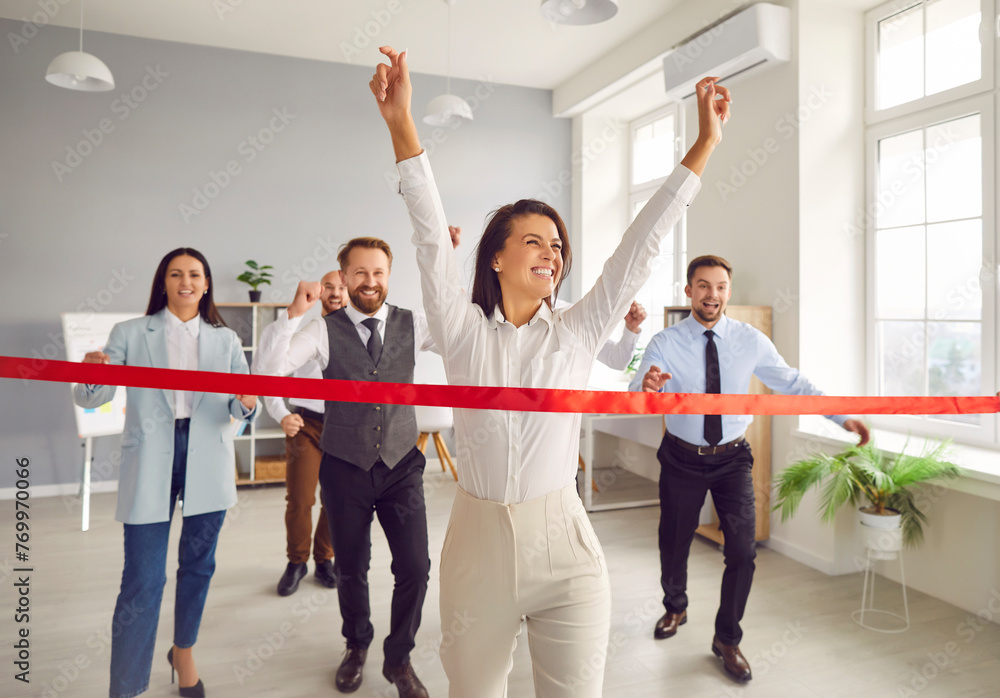 Happy woman employee running to the red ribbon with raised arms ...