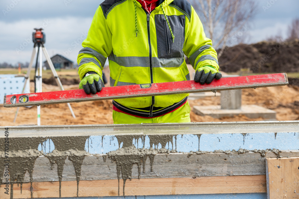 Construction Worker Using Level on Insulated Concrete Forms at Building ...