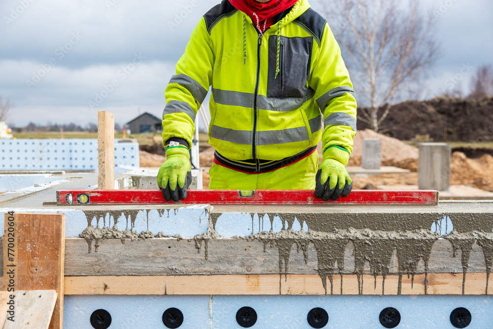 Construction Worker Using Level on Insulated Concrete Forms at Building ...