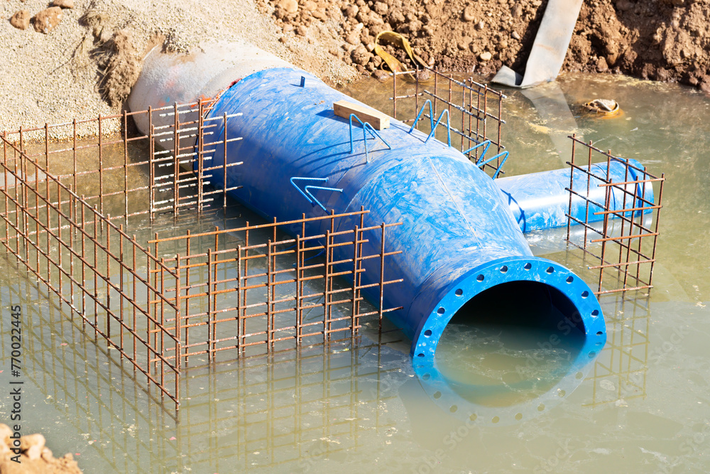 construction workers install pipes and valves for irrigation in fields ...